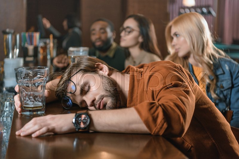 Very drunk young man at bar with ... | Stock image | Colourbox