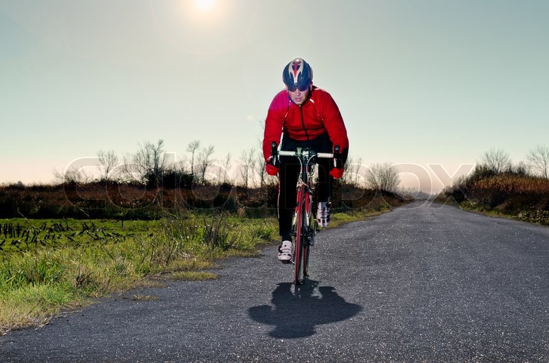 Man on road bike riding down open ... | Stock image | Colourbox