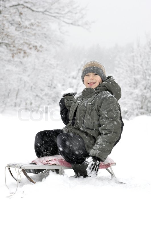 Smiling boy on a sled going to throw ... | Stock image | Colourbox