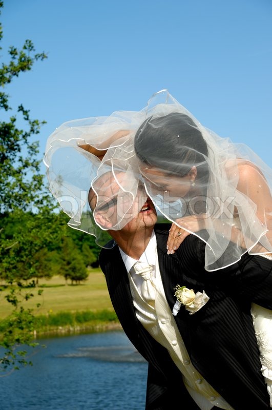 Groom is lifting his bride up in a ... | Stock image | Colourbox
