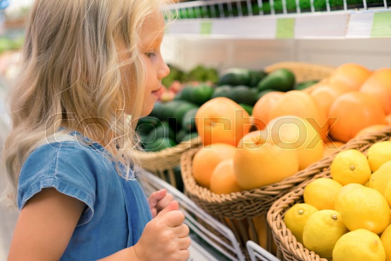 Adorable little kid choosing lemons and ... | Stock image | Colourbox
