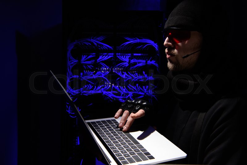Side view of hacker in eyeglasses using ... | Stock image | Colourbox