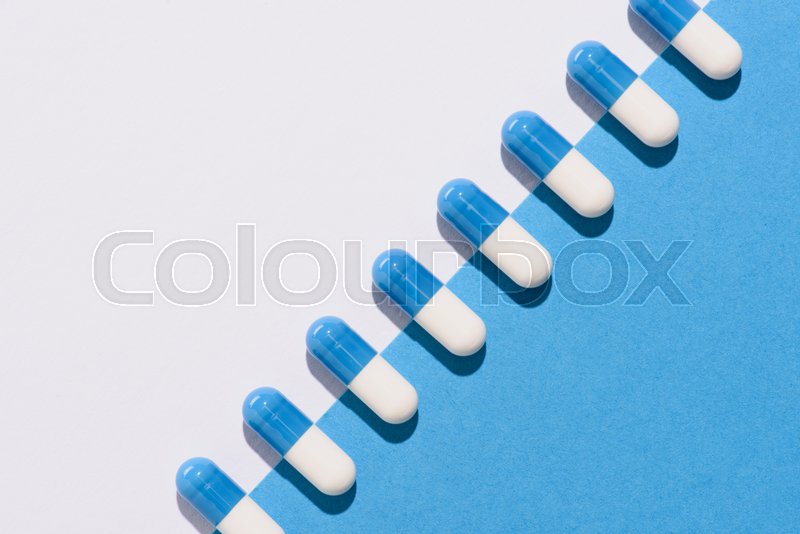 Top view of row of pills on halved ... | Stock image | Colourbox