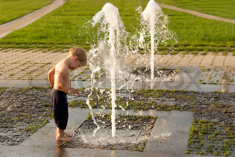 Cute toddler playing in fountain. ... | Stock image | Colourbox