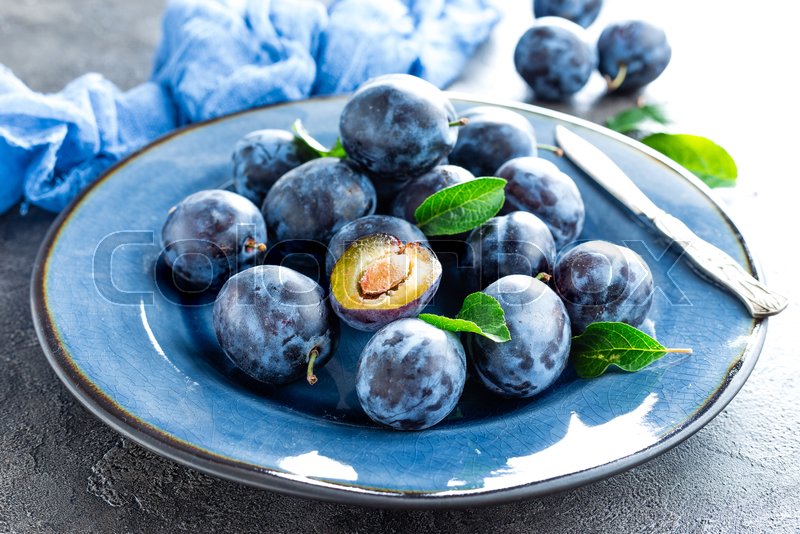 Fresh juicy sweet plums on plate with ... | Stock image | Colourbox