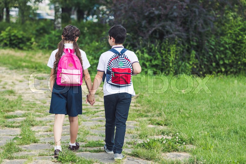 Rear view of schoolchildren walking by ... | Stock image | Colourbox