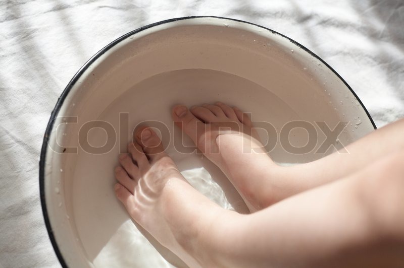 Child's feet in a wash-basin with water | Stock image | Colourbox