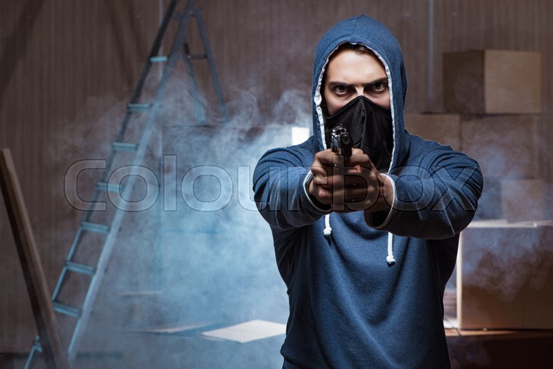Aggressive manwith gun wearing face ... | Stock image | Colourbox