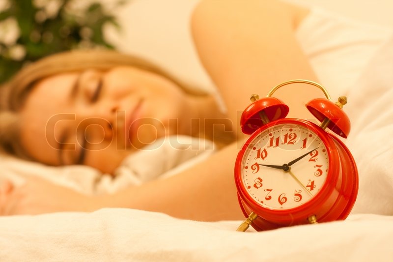 Red alarm and woman sleep on background | Stock image | Colourbox