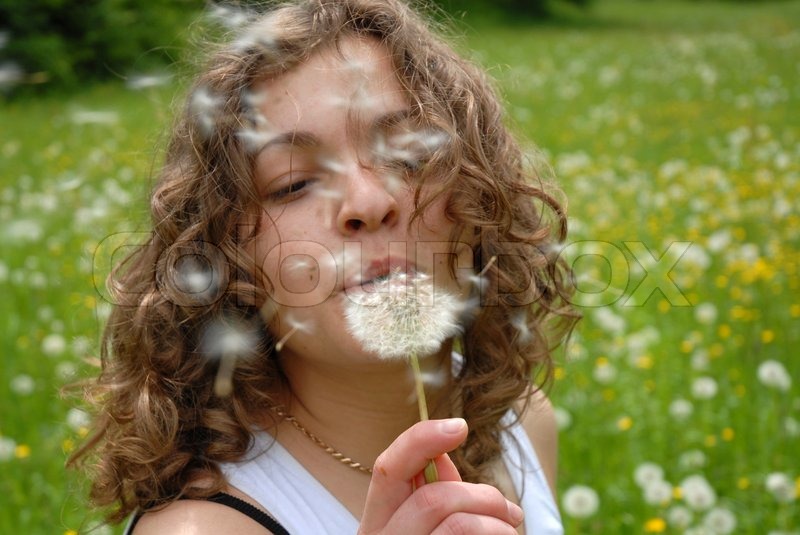 Girl is blowing on dandelion | Stock image | Colourbox