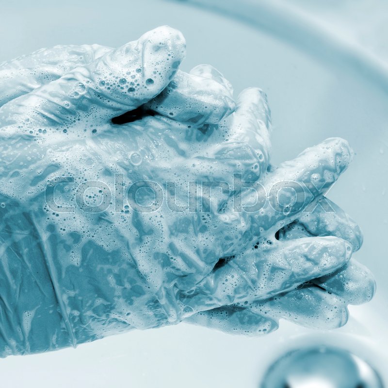 Someone wearing surgical gloves washing ... | Stock image | Colourbox