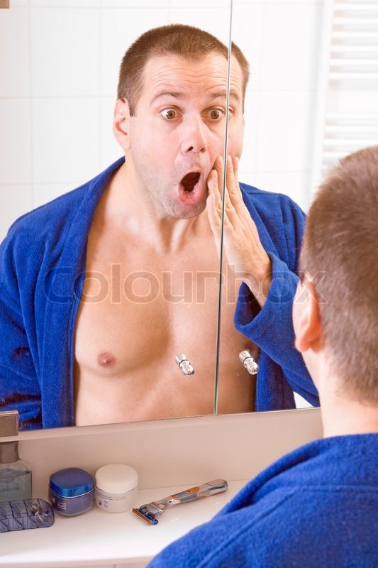 Man looks at himself in the mirror | Stock Photo | Colourbox