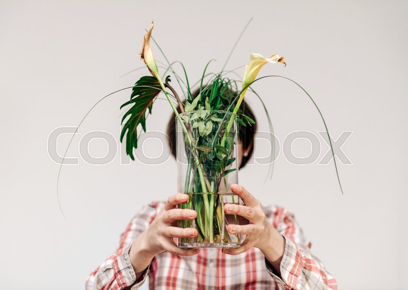 Woman hiding her face behind flower ... | Stock image | Colourbox