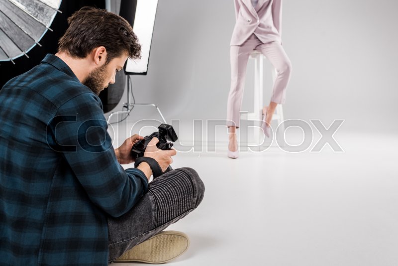Photographer sitting with camera and ... | Stock image | Colourbox