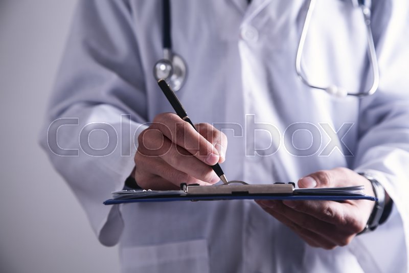 Doctor taking notes in medical history ... | Stock image | Colourbox