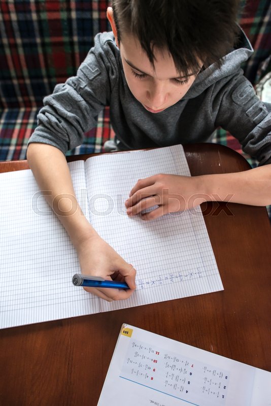 Boy do his homework. Notebook | Stock image | Colourbox