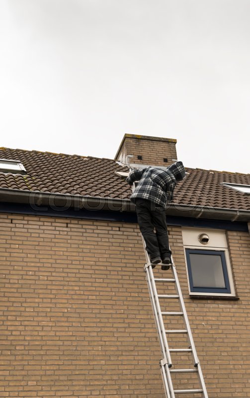 Man climbing on a ladder doing ... | Stock image | Colourbox