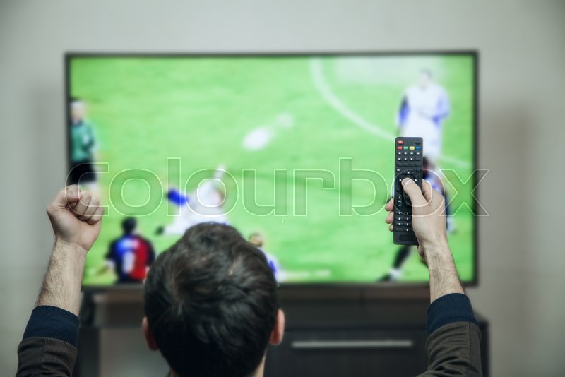 Caucasian man watching football on ... | Stock image | Colourbox