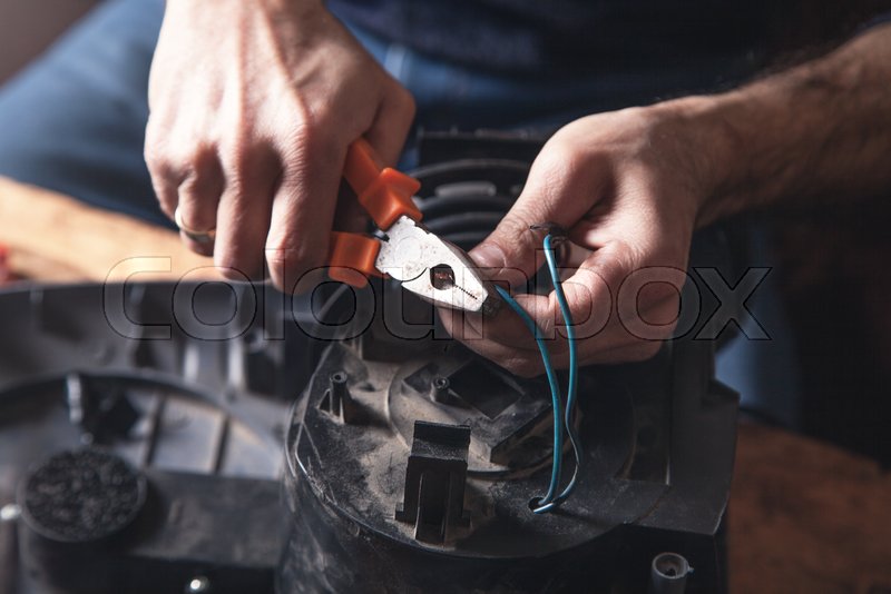 Electrician cutting cable with cutters. | Stock image | Colourbox