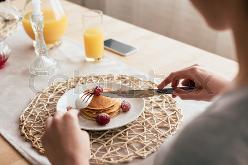 Partial view of woman eating pancakes ... | Stock image | Colourbox