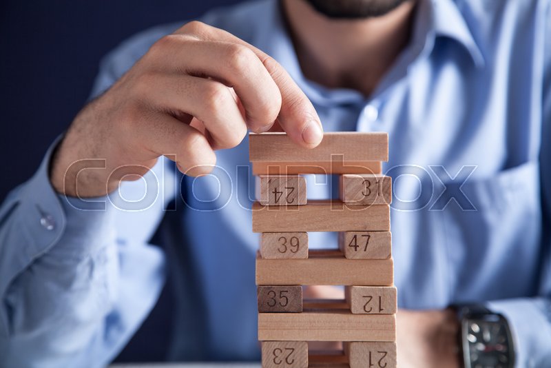 Man stacking wooden blocks. Development ... | Stock image | Colourbox
