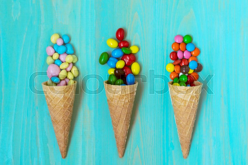 Three wafer cones with colored candy on ... | Stock image | Colourbox