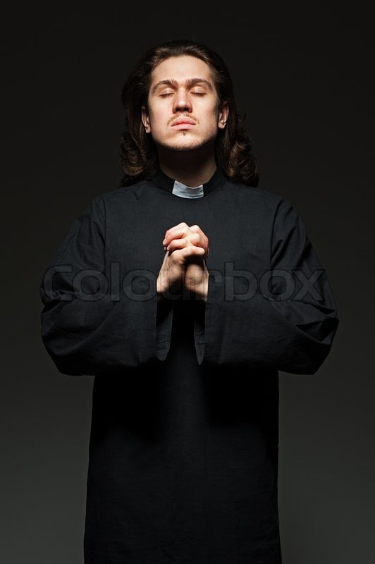 Young priest is praying | Stock image | Colourbox