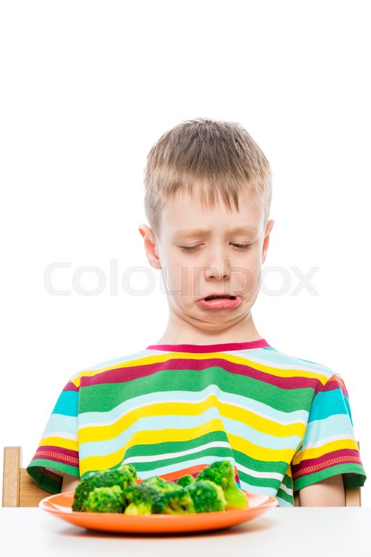 Boy with disgust looks at a plate of ... | Stock image | Colourbox