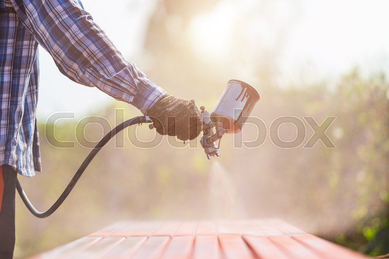 Construction worker spraying paint to ... | Stock image | Colourbox