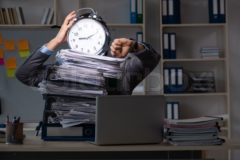 The young male employee working late at ... | Stock image | Colourbox