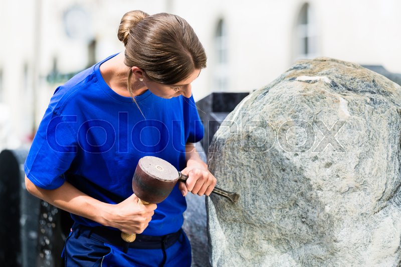 Female stonemason working on boulder ... | Stock image | Colourbox