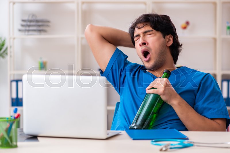 Young male doctor drinking in the ... | Stock image | Colourbox