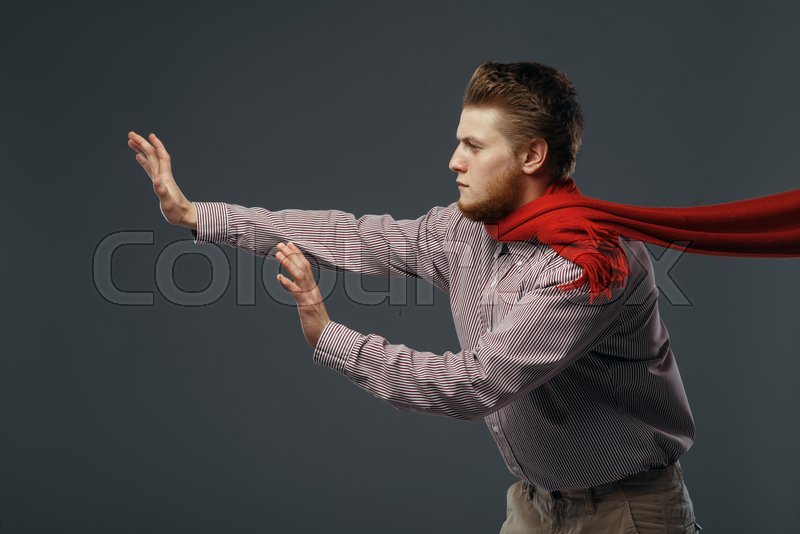 Strong wind blowing on man in red ... | Stock image | Colourbox