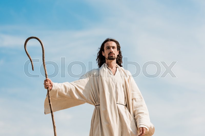 Jesus holding wooden cane against blue ... | Stock image | Colourbox