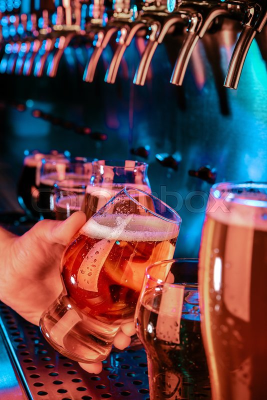 Hand of bartender pouring a large lager ... | Stock image | Colourbox