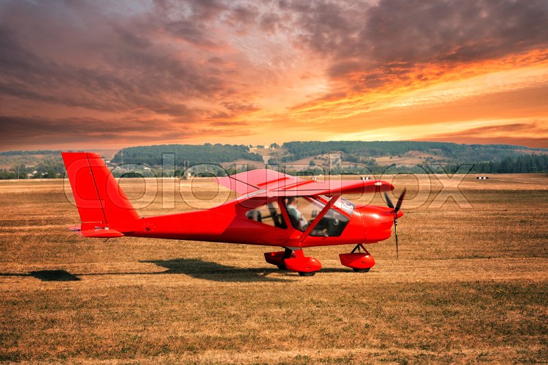 Red airplane at the airport. Dramatic ... | Stock image | Colourbox