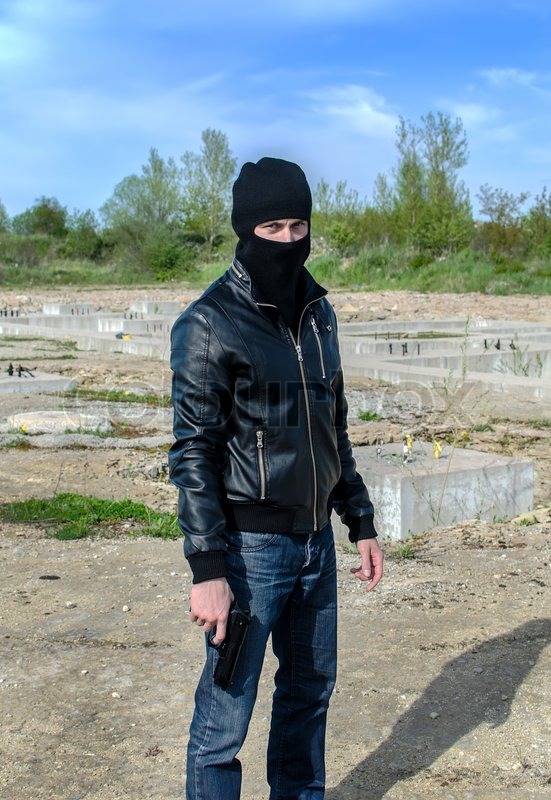 Thug in a mask with a gun in his hand | Stock image | Colourbox