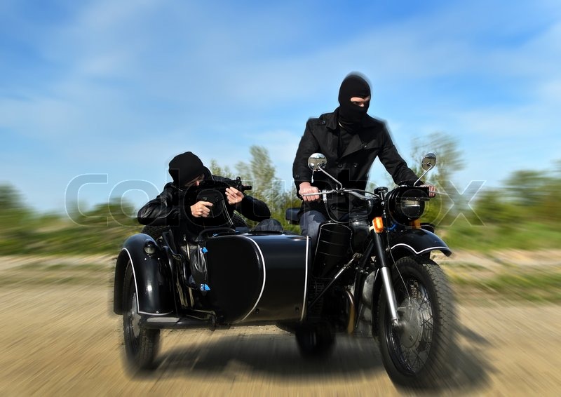 Two armed men riding a motorcycle with ... | Stock image | Colourbox