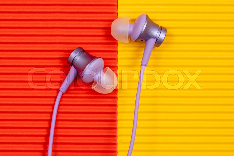 Purple audio earphones on the colorful ... | Stock image | Colourbox