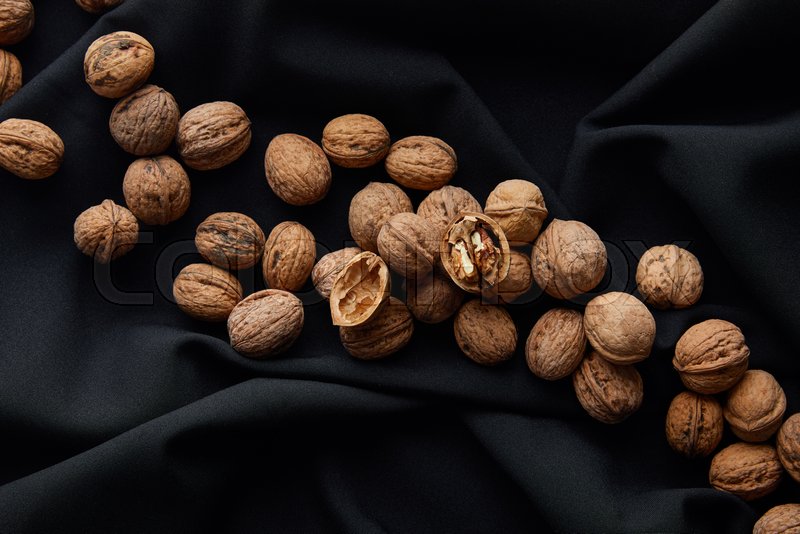 Top view of brown nuts on black cloth | Stock image | Colourbox