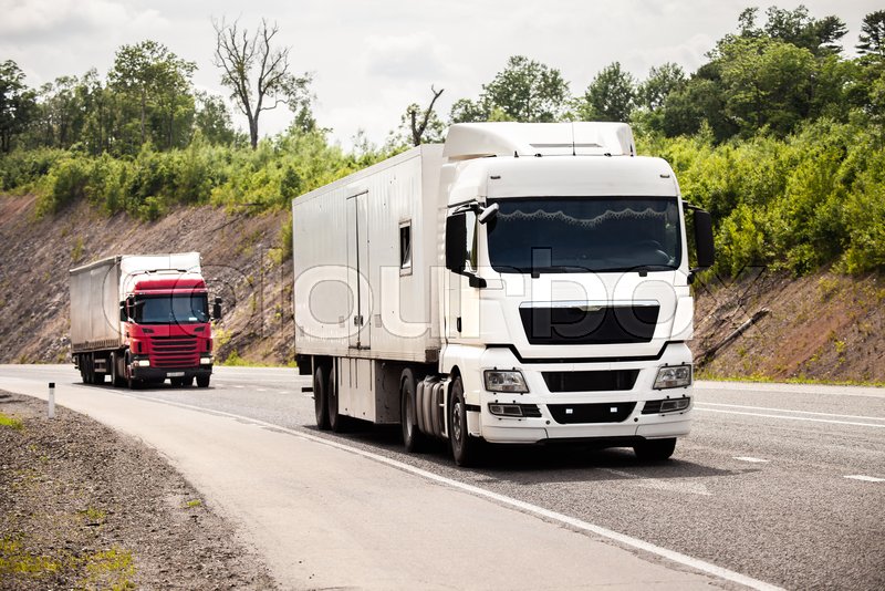 Two trucks moving by a road in summer | Stock image | Colourbox
