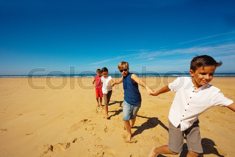Kids Holding Hands On The Beach