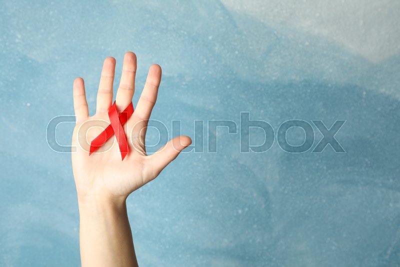 Hand and red awareness ribbon against ... | Stock image | Colourbox