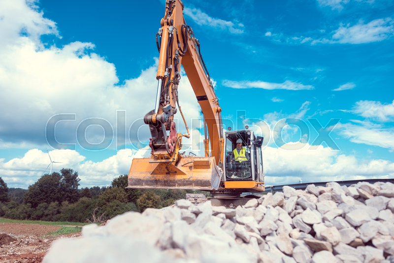 Woman operating an excavator on road ... | Stock image | Colourbox