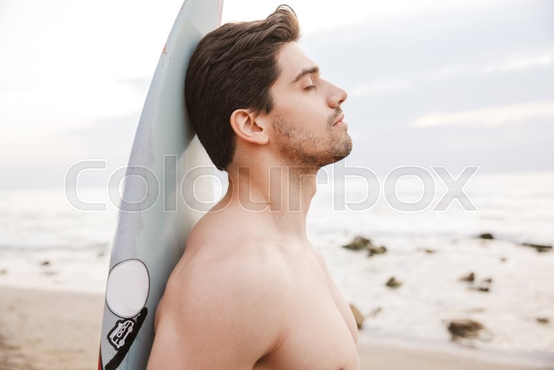 Photo of a handsome man surfer with ... | Stock image | Colourbox