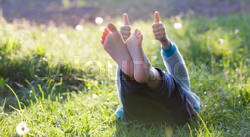 Happy little boy lying on green grass ... | Stock image | Colourbox