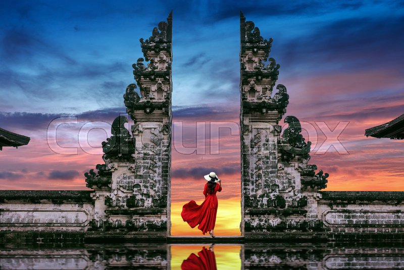 Young woman standing in temple gates at ... | Stock image | Colourbox