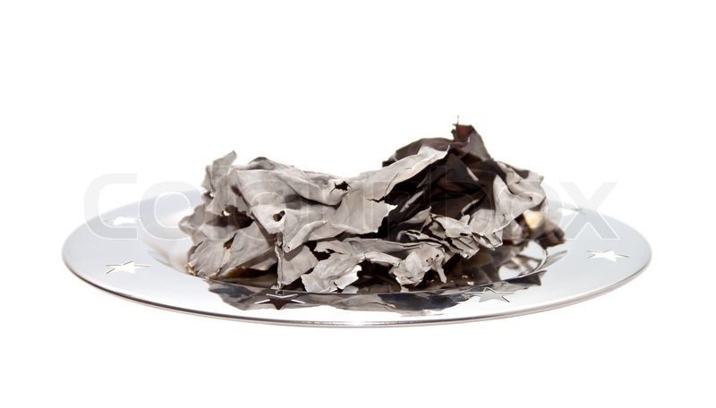 Ashes of burnt paper on a plate | Stock Photo | Colourbox