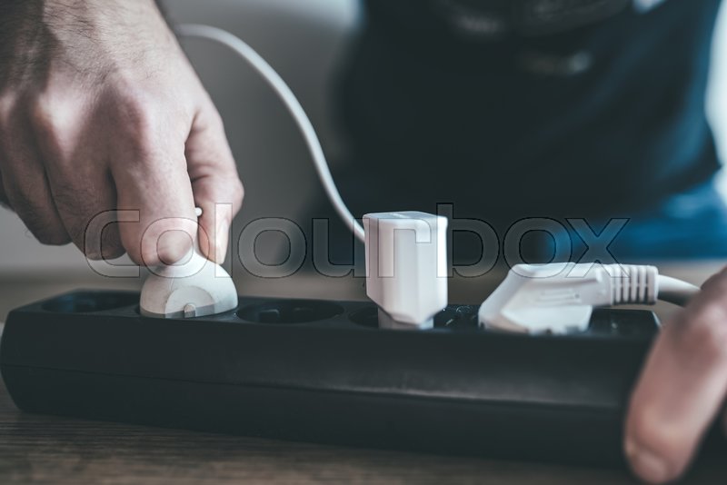 Close-up of hand plugging power cable ... | Stock image | Colourbox