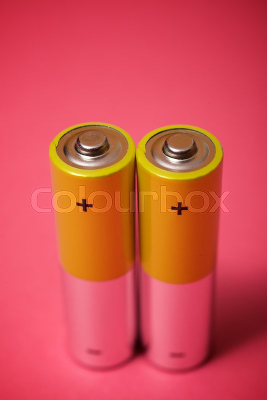 Two small batteries on a pink table. | Stock image | Colourbox